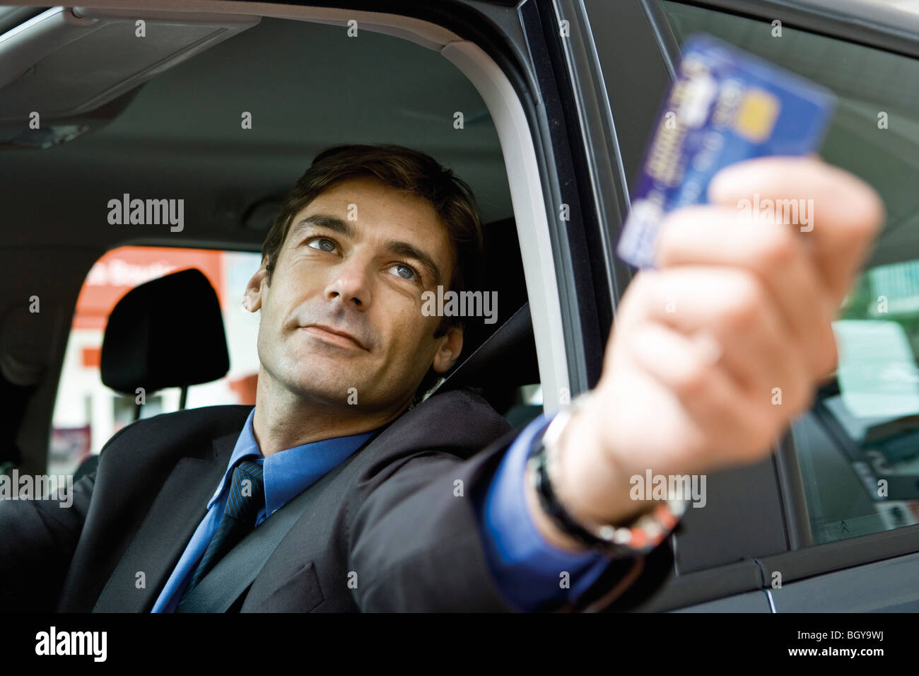 Customer in drive-thru handing credit card to check-out window clerk ...