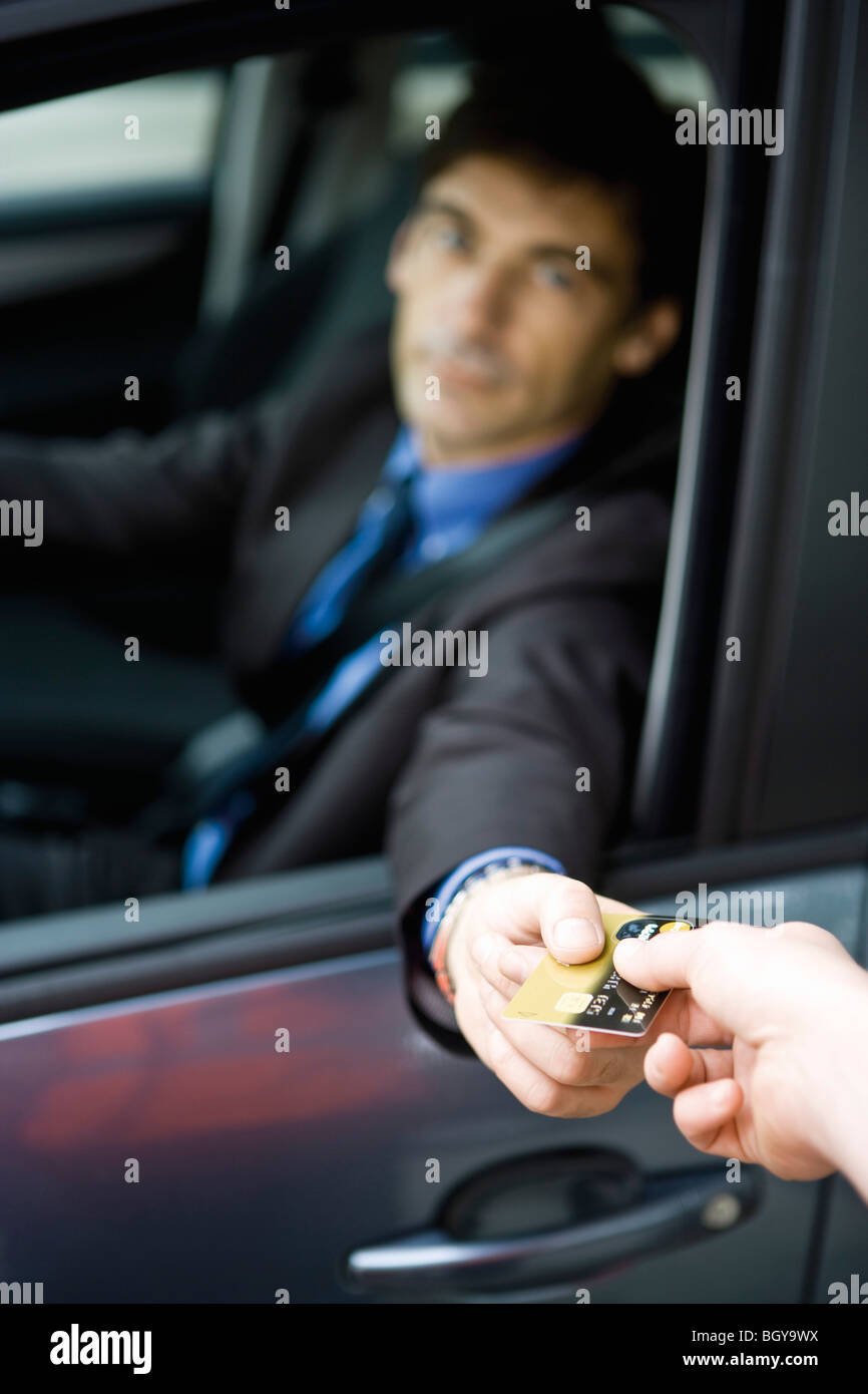 Customer in drive-thru handing credit card to check-out window clerk ...