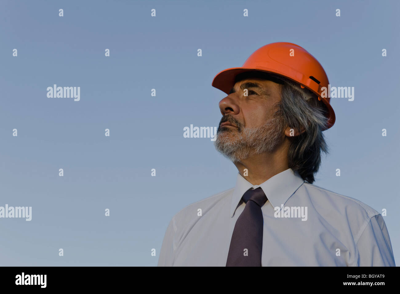 Engineer wearing hard hat, looking away Stock Photo - Alamy