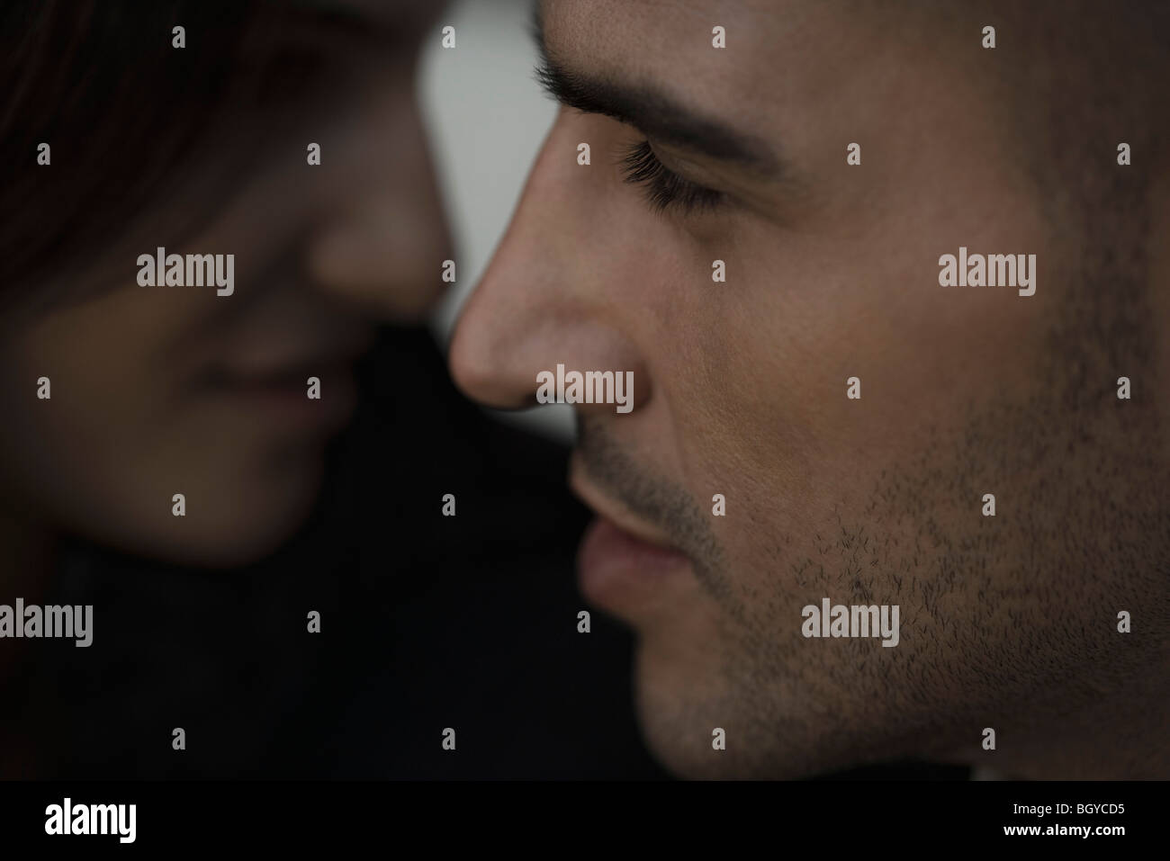 Couple face to face, focus on man's profile Stock Photo - Alamy