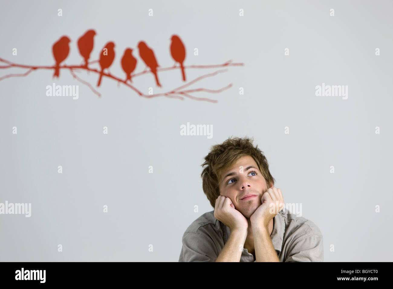 Young man daydreaming, chin resting on hands Stock Photo - Alamy