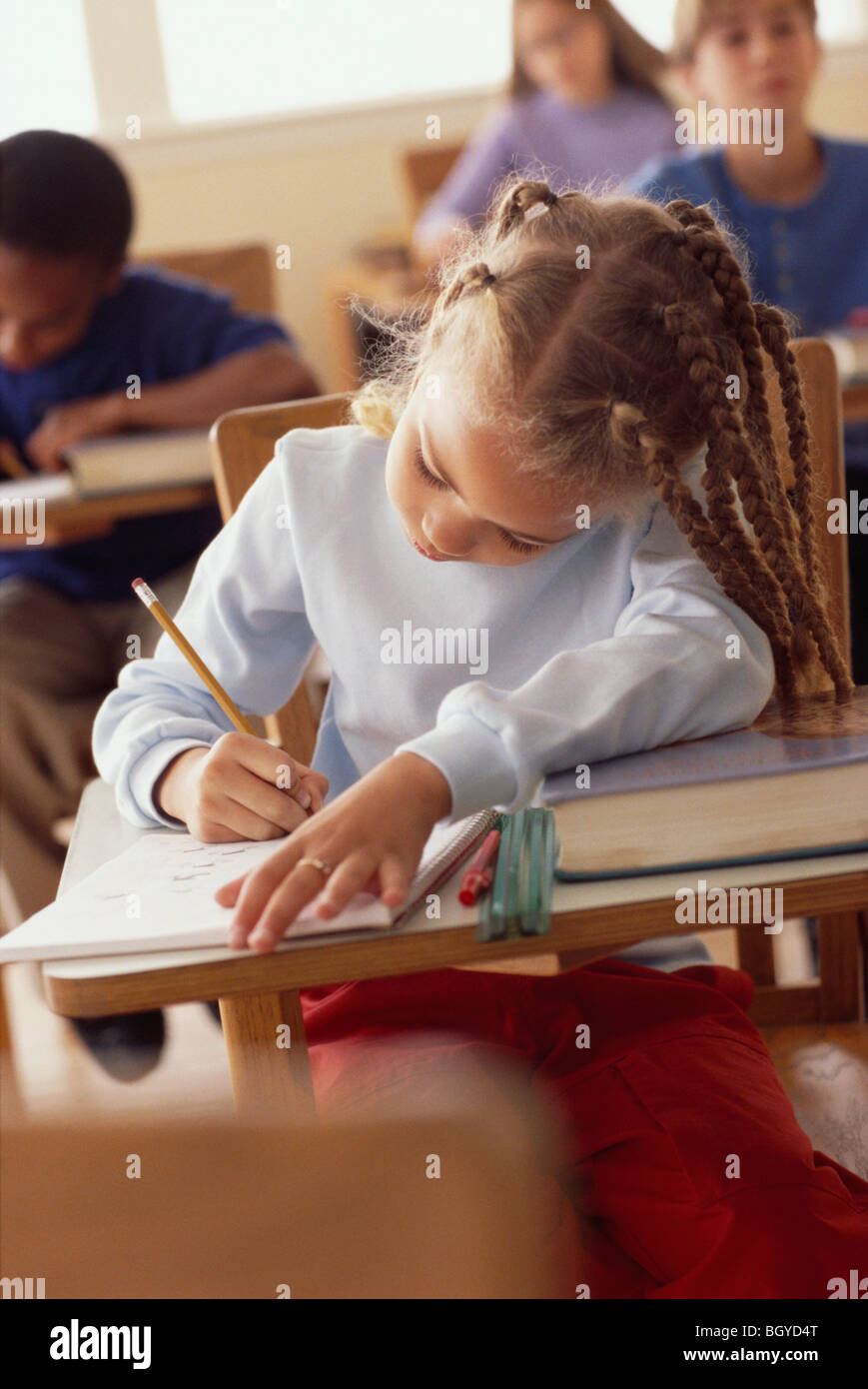 Student writing at desk Stock Photo - Alamy
