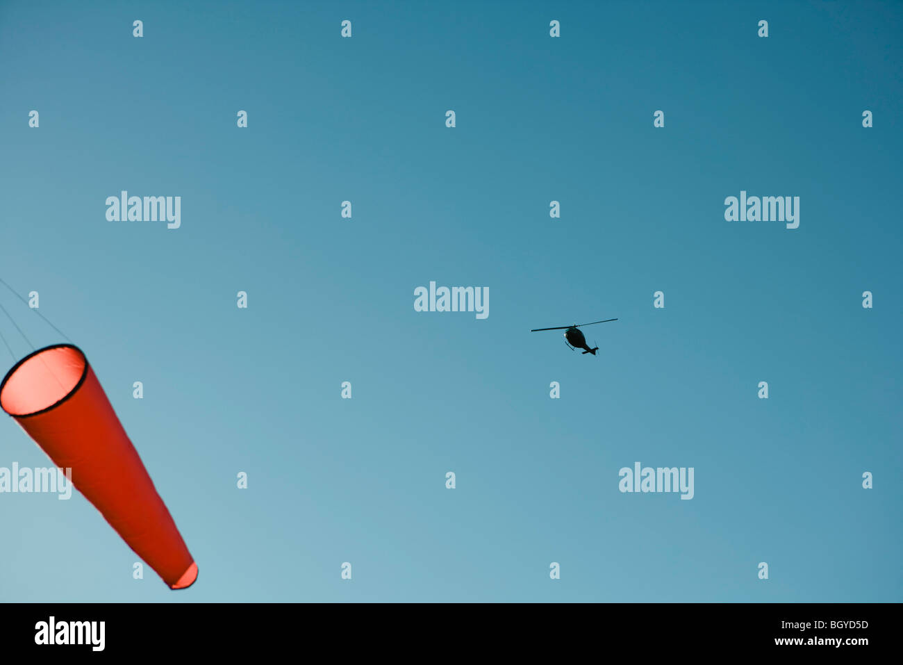 Helicopter flying above windsock in sky, low angle view Stock Photo - Alamy