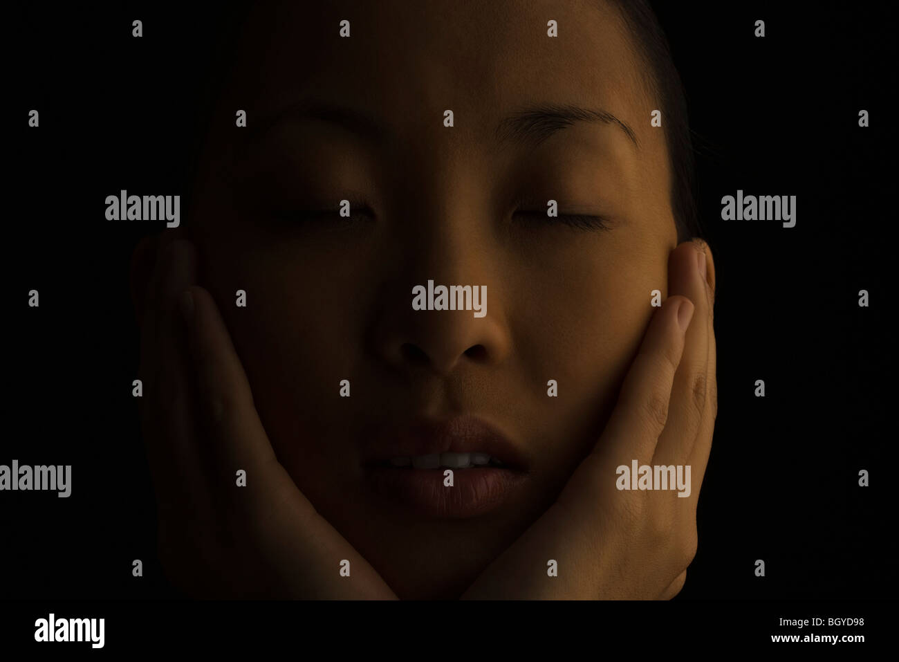 Woman holding face in hands, eyes closed Stock Photo - Alamy