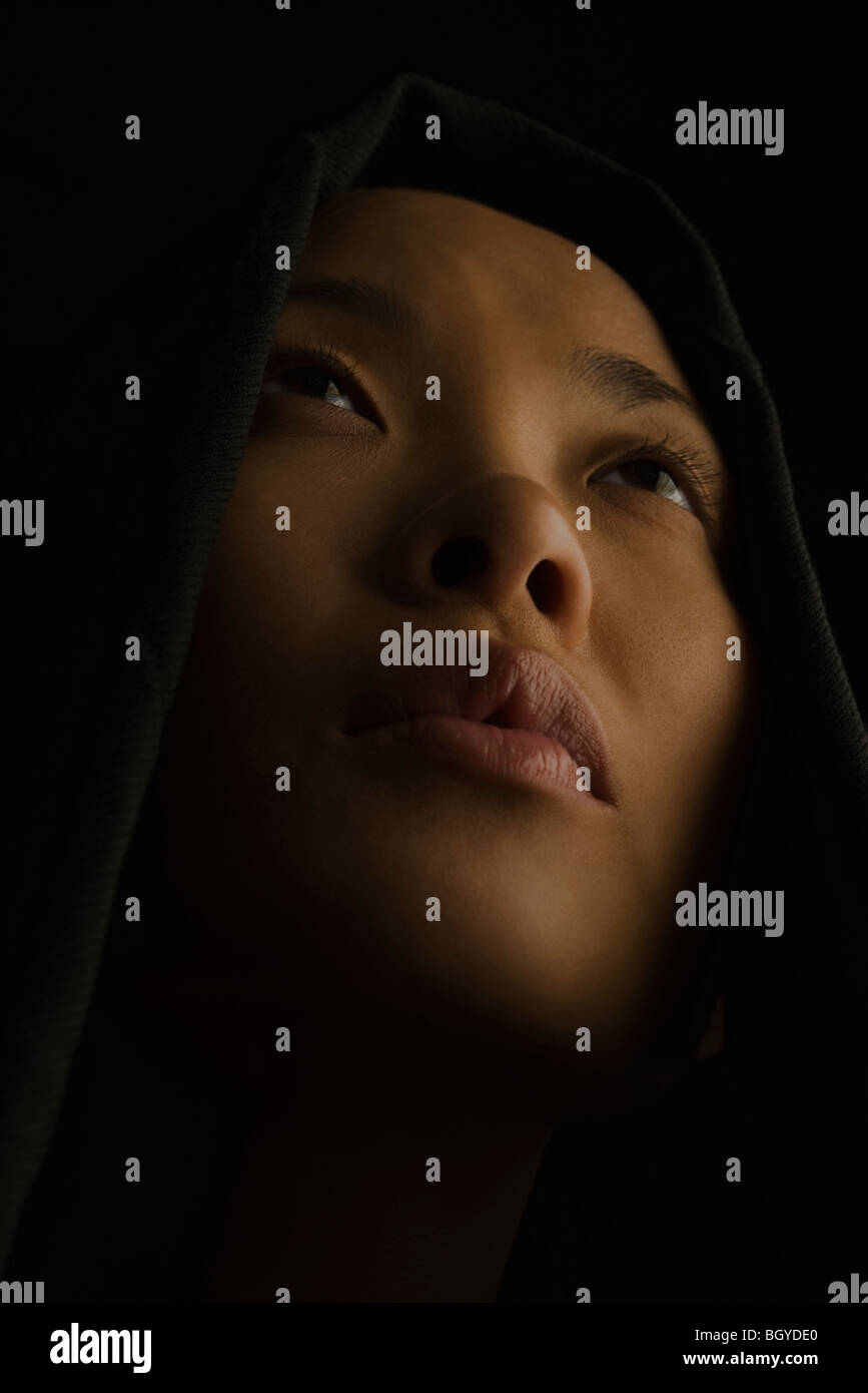 Woman wearing hood, looking up hopefully Stock Photo - Alamy