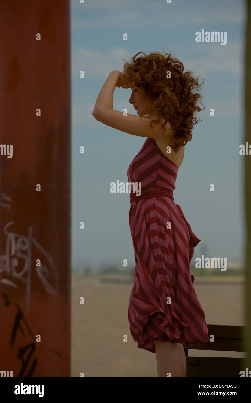 Young woman standing near coast, looking to distance Stock Photo - Alamy