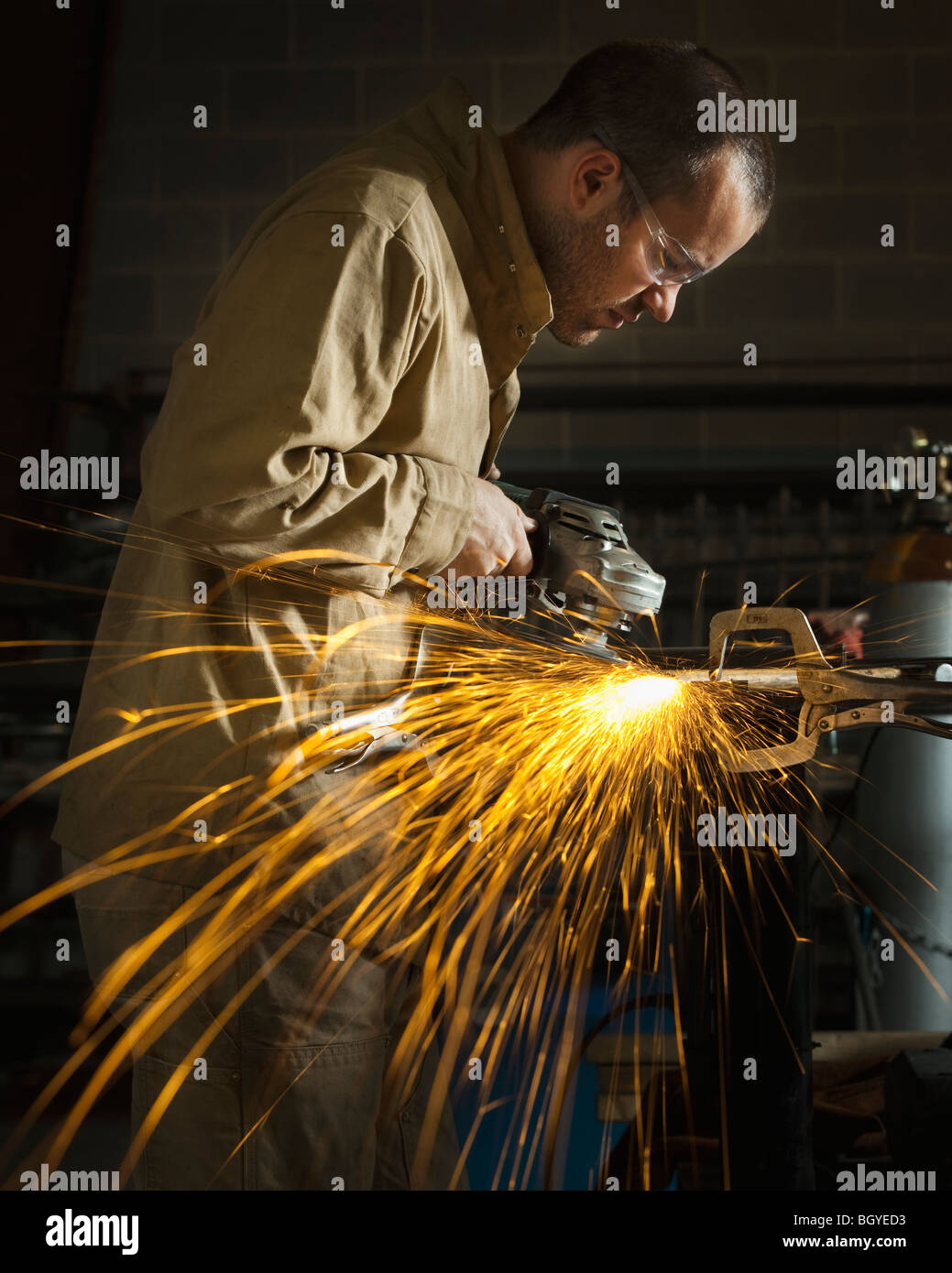 Steel grinder working in metal shop Stock Photo - Alamy
