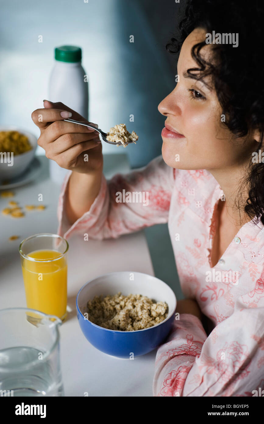Young woman eating breakfast, smiling Stock Photo - Alamy