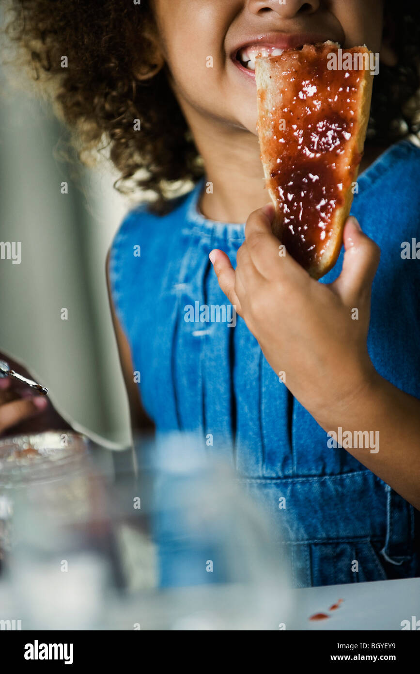 Little girl eating bread and jam, cropped Stock Photo - Alamy