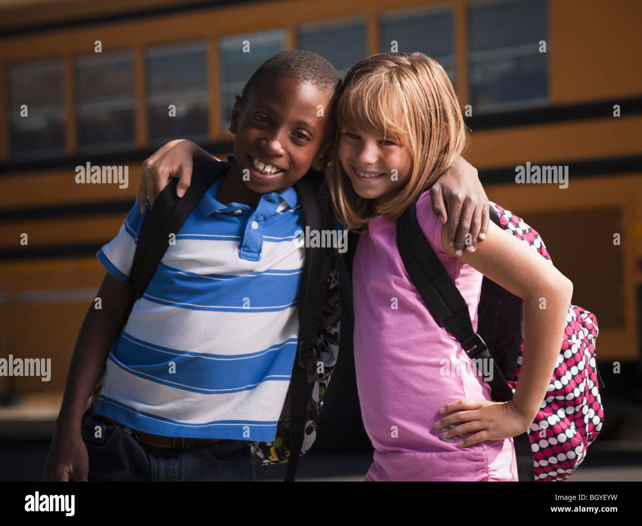 Friends in front of school bus Stock Photo - Alamy