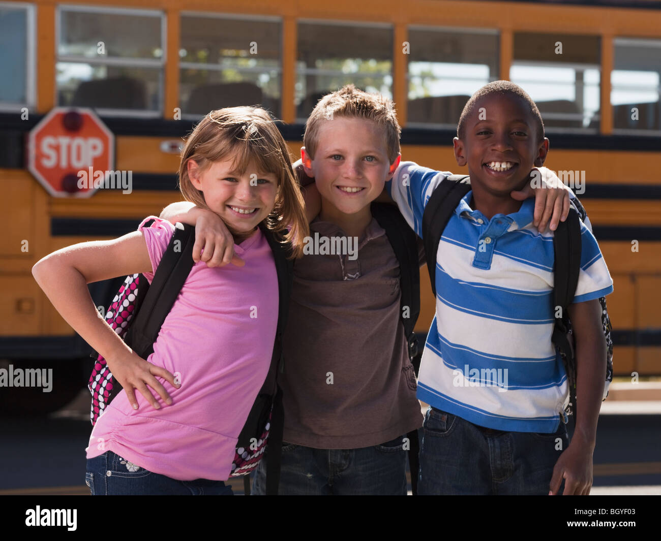 Friends in front of school bus Stock Photo - Alamy