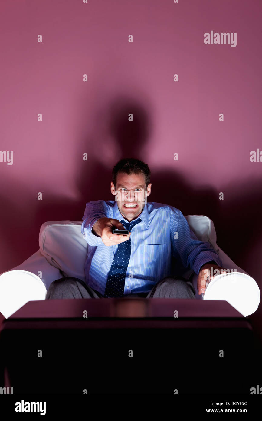 Angry man using remote control Stock Photo - Alamy