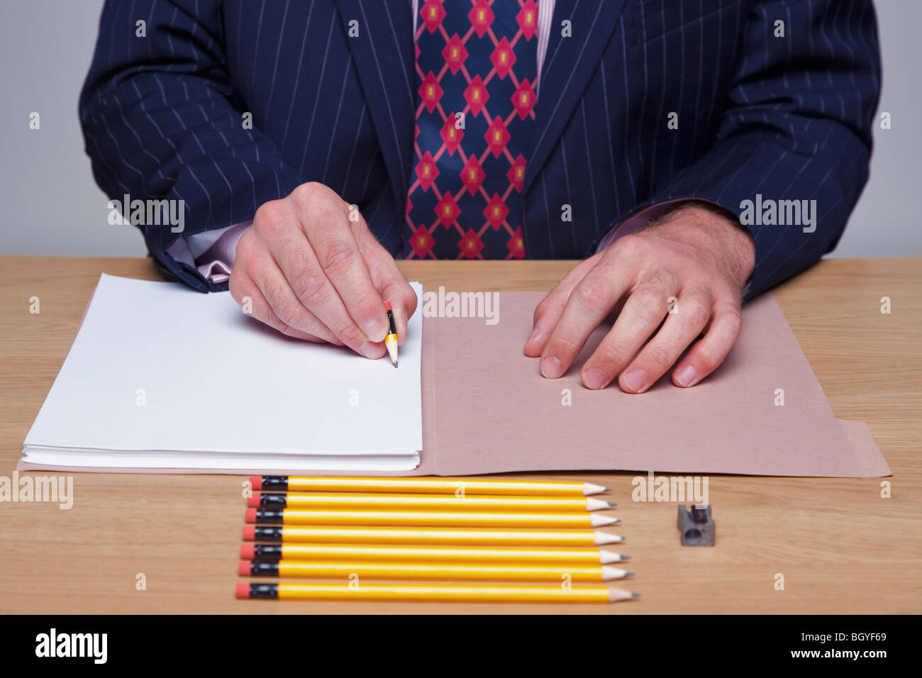 Man writing on paper with tiny pencil Stock Photo - Alamy