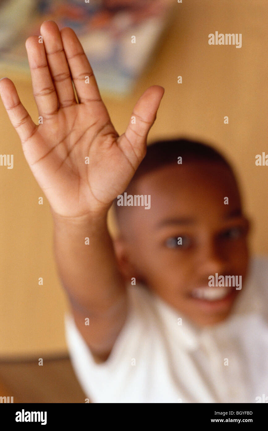 Child raising hand in classroom Stock Photo - Alamy