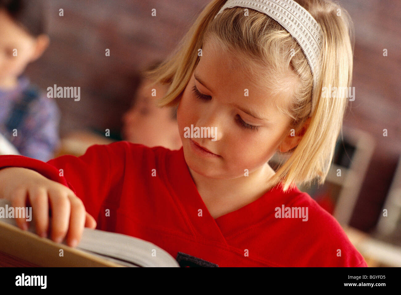 Student reading book in classroom Stock Photo - Alamy