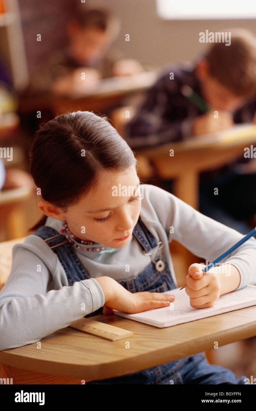 Student writing in classroom Stock Photo - Alamy