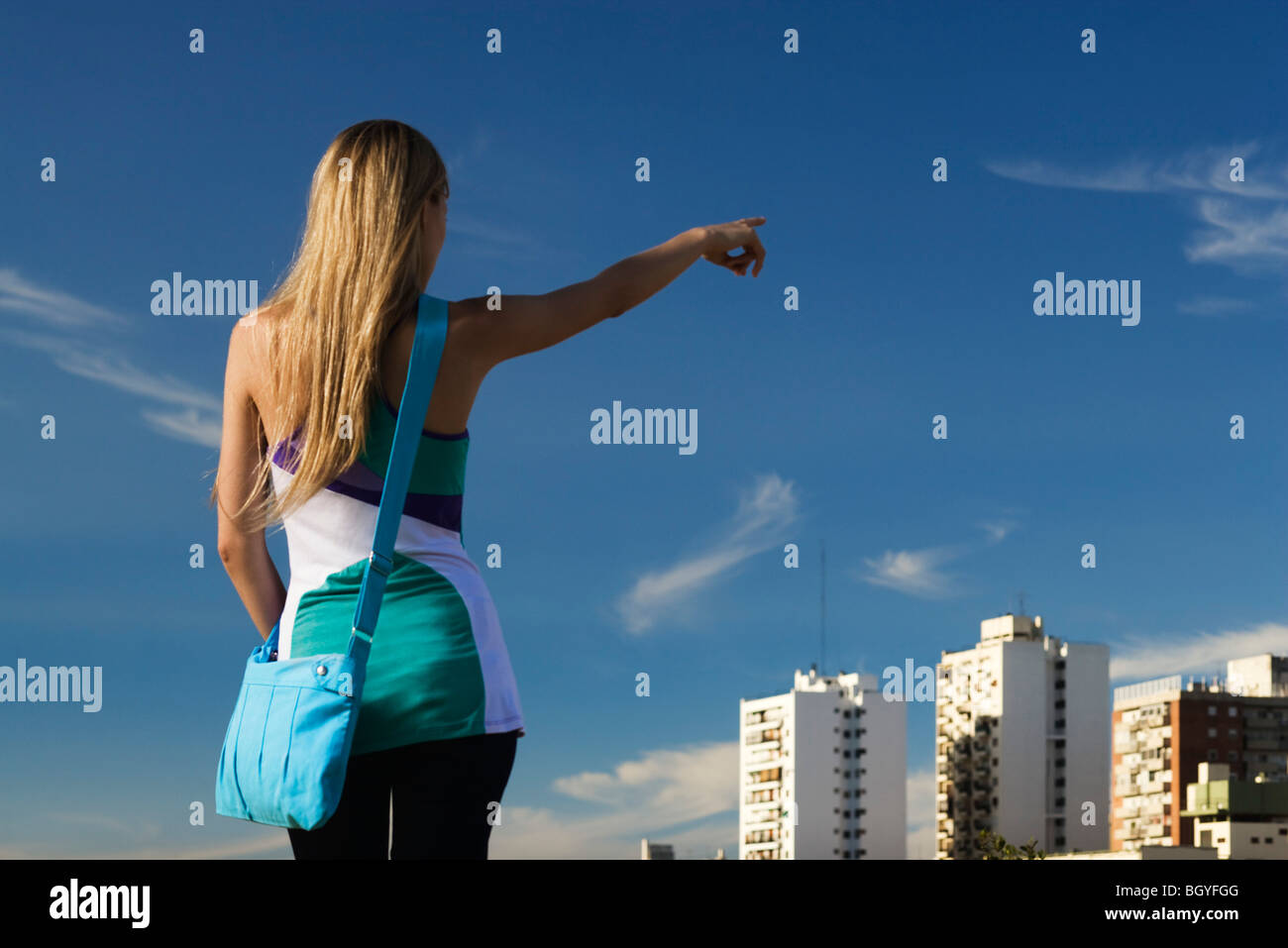 Female pointing at sky, city in distance Stock Photo - Alamy