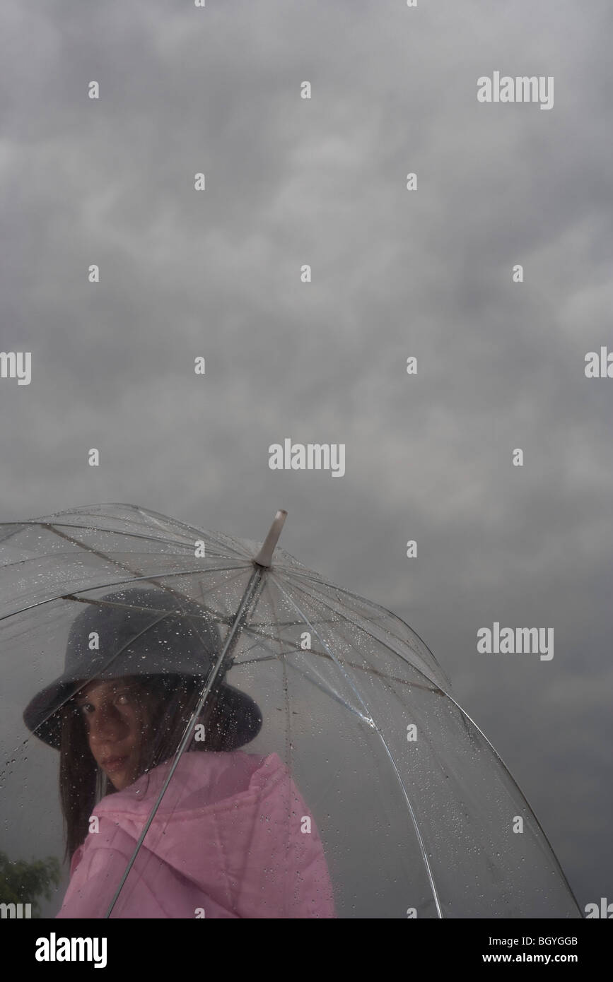 Female with transparent umbrella looking over shoulder at camera Stock ...