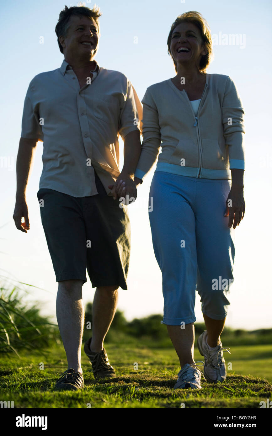 Mature couple holding hands enjoying walk together Stock Photo - Alamy