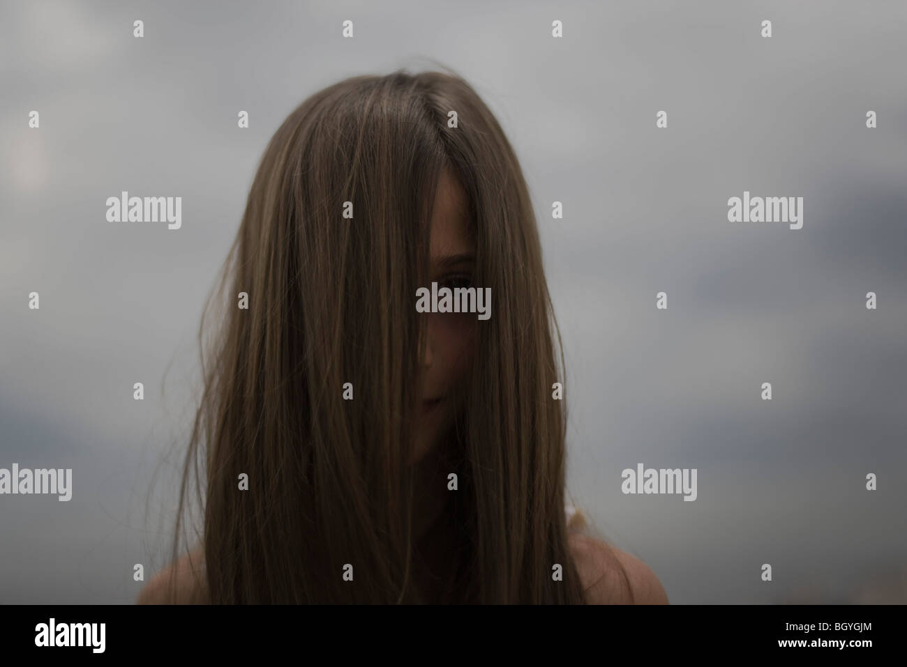 Female with face obscured by long hair looking at camera Stock Photo ...
