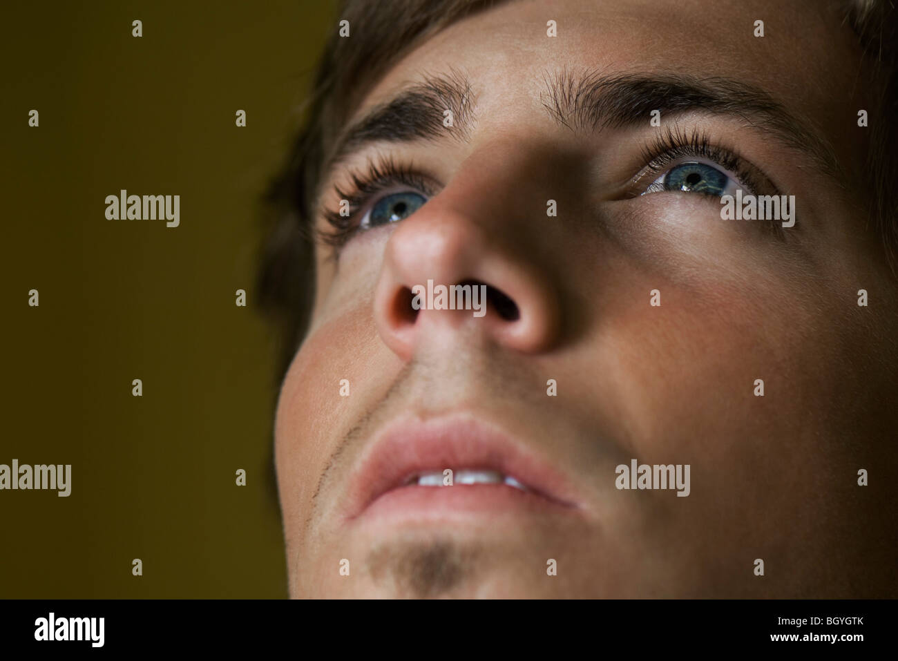 Young man looking up hopefully Stock Photo - Alamy