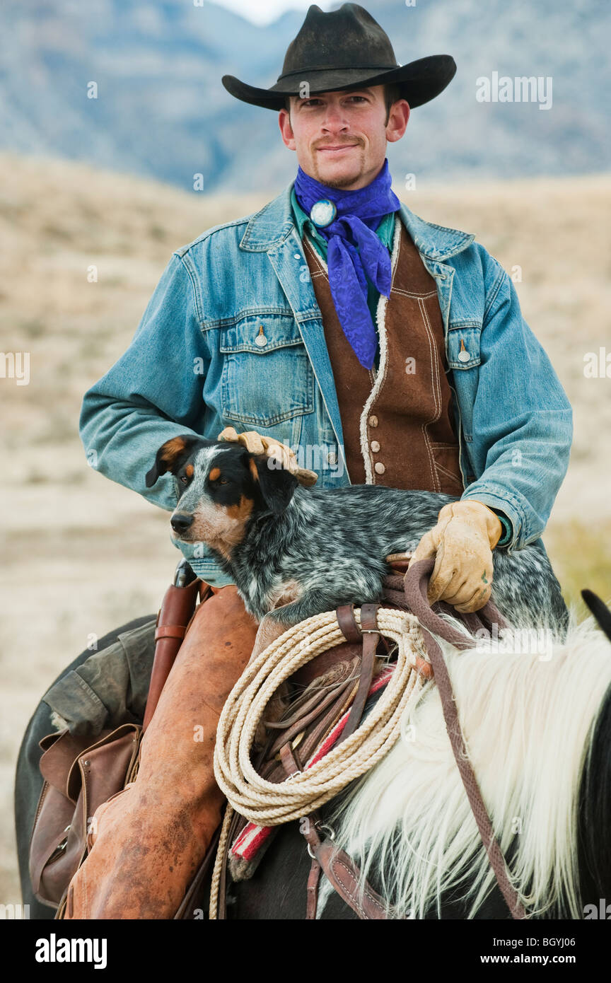 Cowboy and dog on horse Stock Photo - Alamy