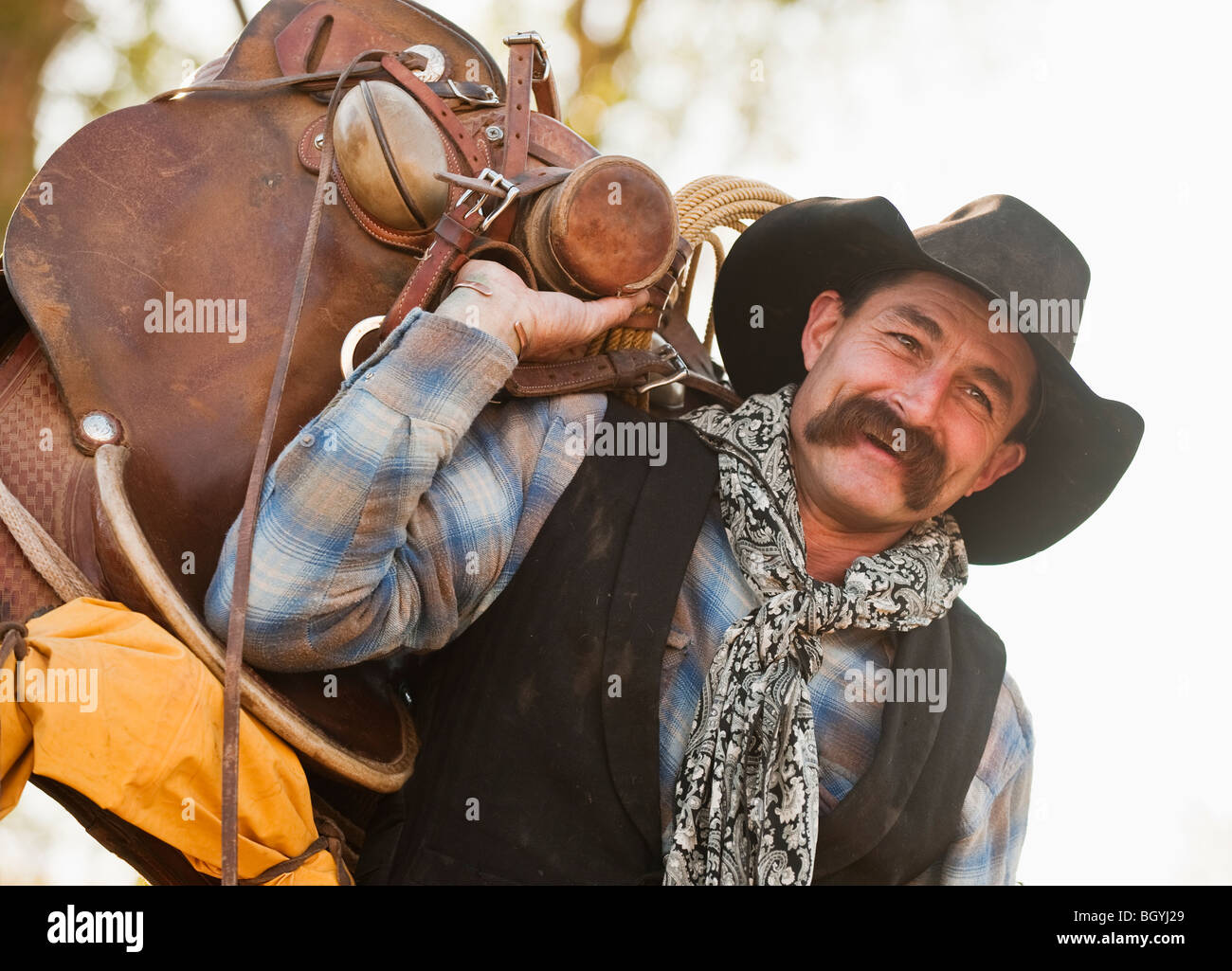Cowboy holding saddle hi-res stock photography and images - Alamy