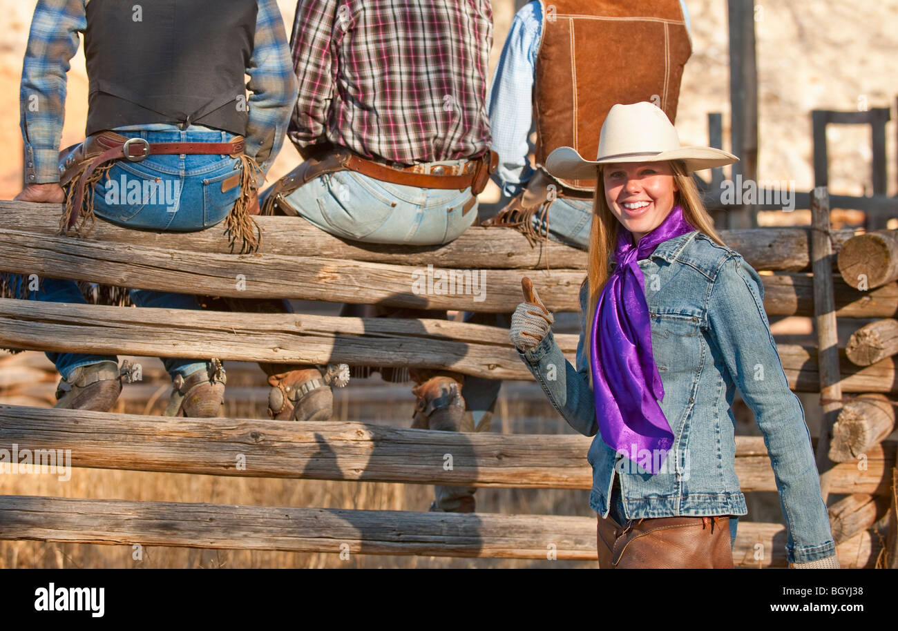 Cowboys sitting on fence Stock Photo - Alamy