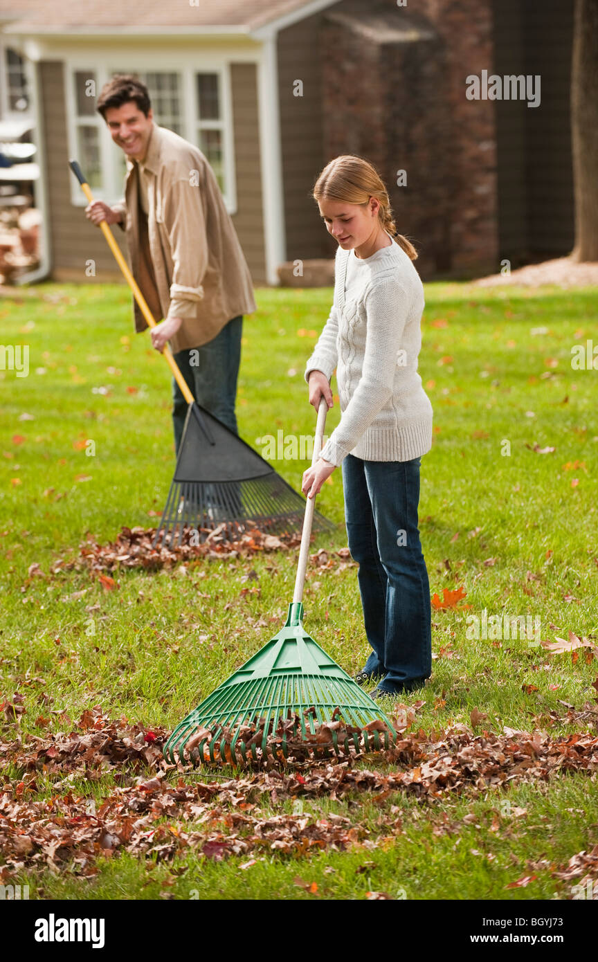 Man and girl raking leaves Stock Photo - Alamy
