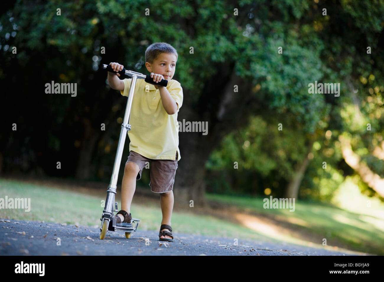 Boy riding scooter Stock Photo - Alamy