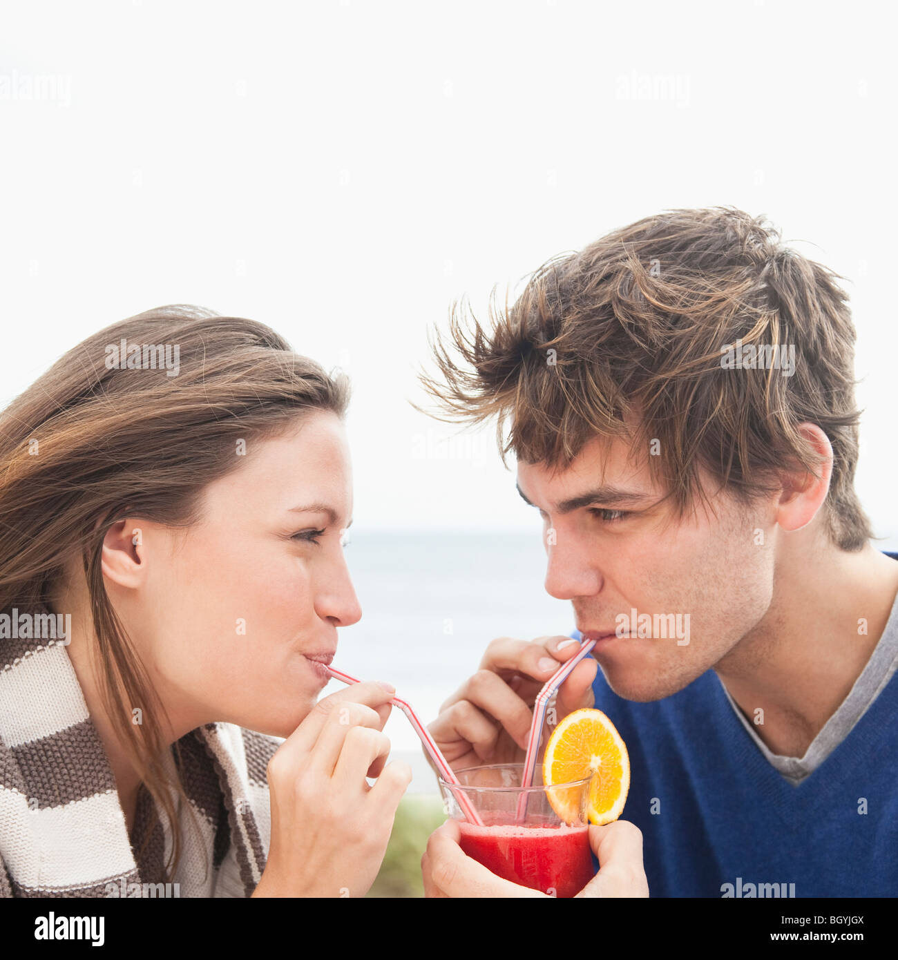 Couple sharing drink Stock Photo - Alamy