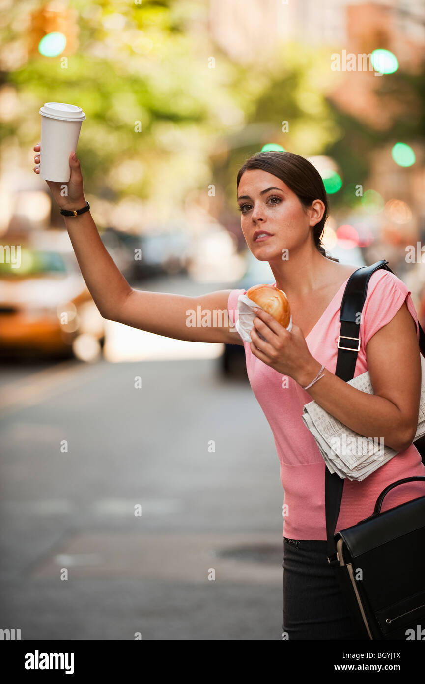 Woman hailing cab Stock Photo - Alamy