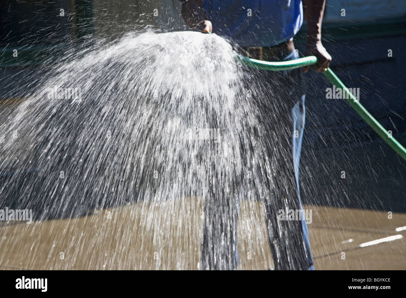Man spraying hose Stock Photo - Alamy