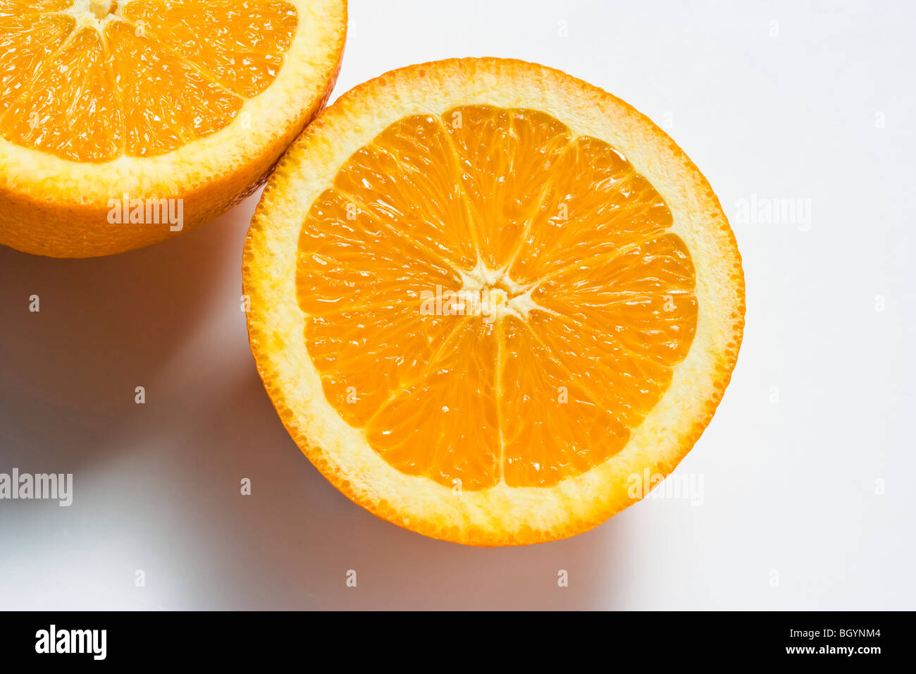 Two orange halves on white background Stock Photo - Alamy