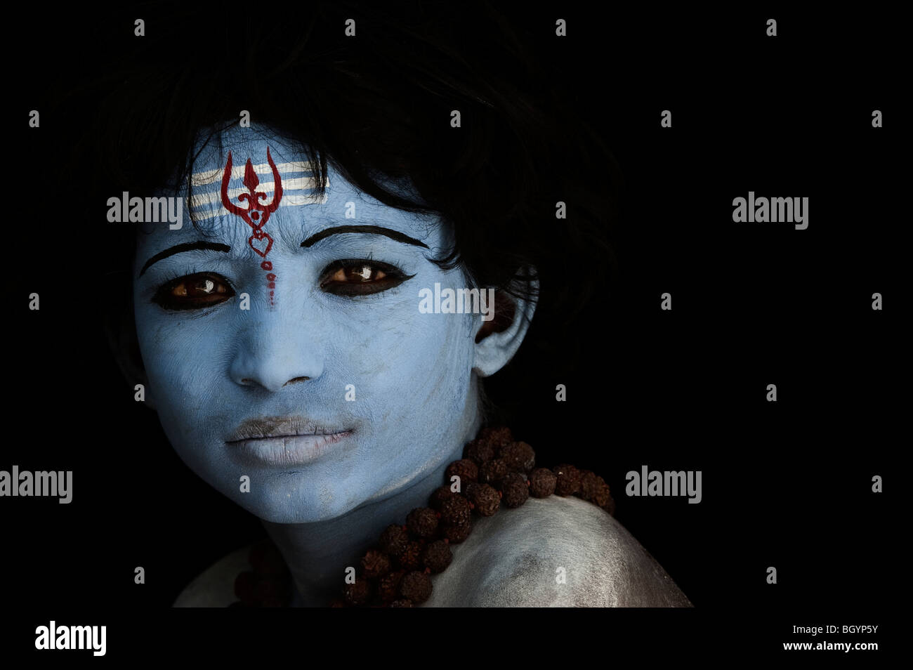 Indian boy, face painted as the Hindu god Shiva against a black ...