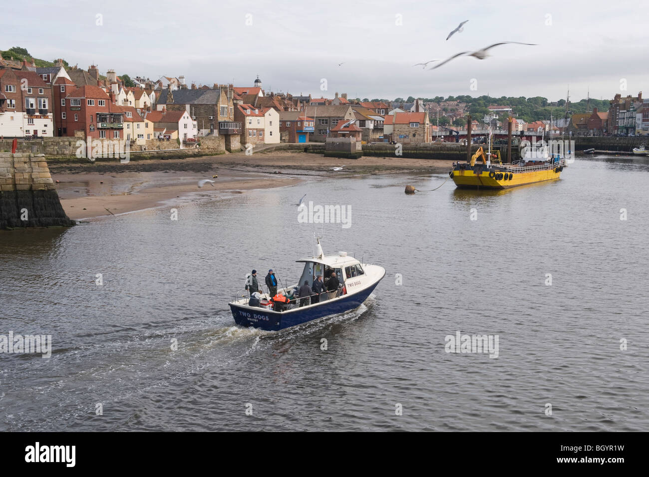 A small boat entering Whitby's outer harbour Stock Photo - Alamy