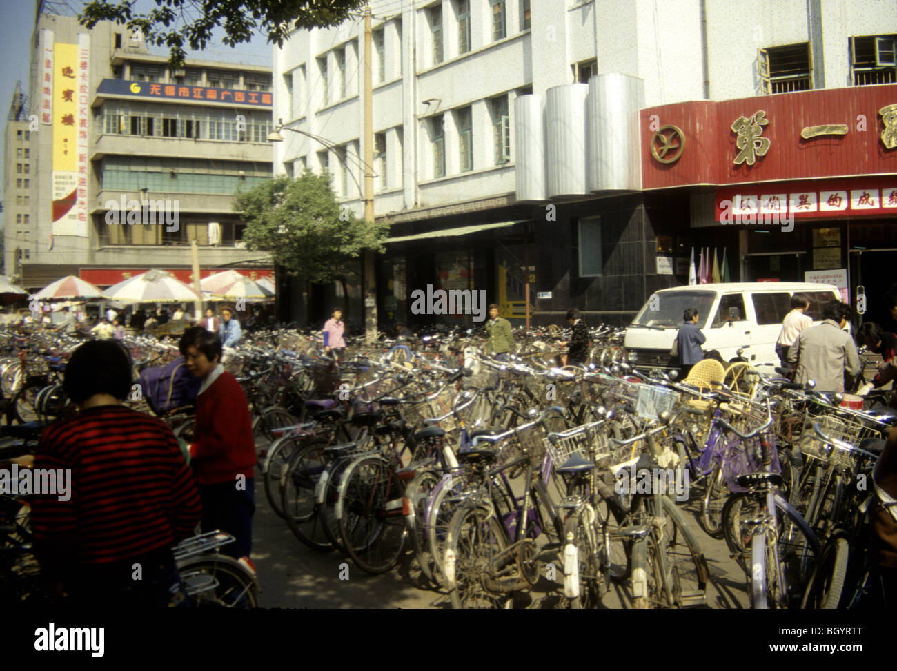 Hundreds of Chinese commuter bicycles are parked along a street on a ...