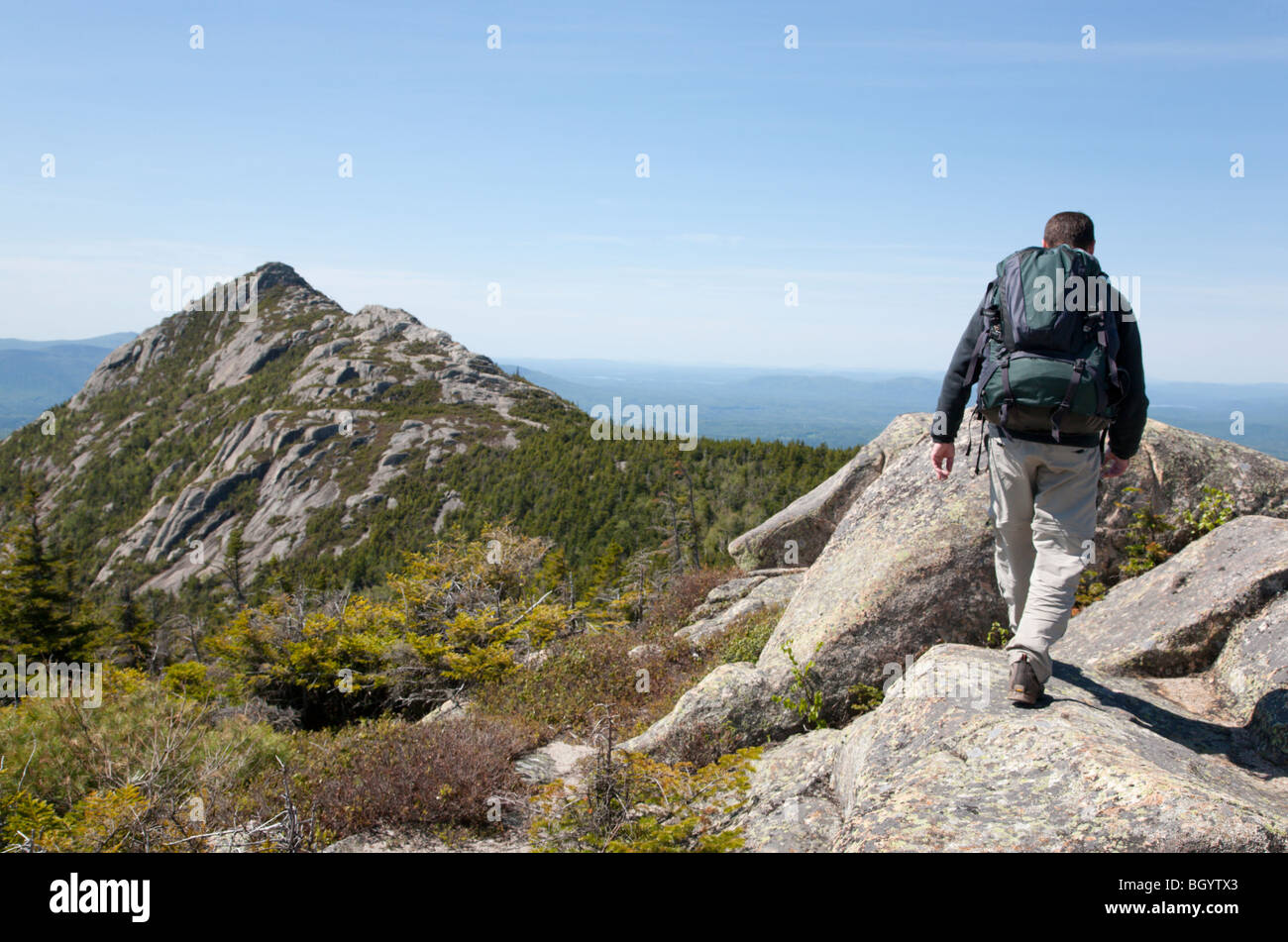 A hiker on Middle Sister Trail with Mount Chocorua in the background ...