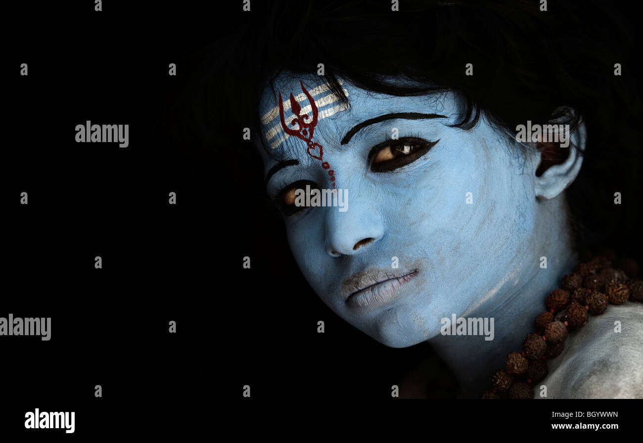 Indian boy, face painted as the Hindu god Shiva against a black ...