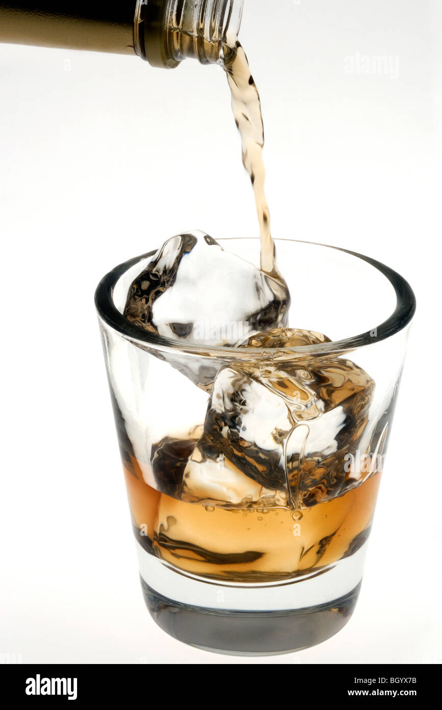 Whiskey poured on the rocks in an old fashioned glass on a white ...