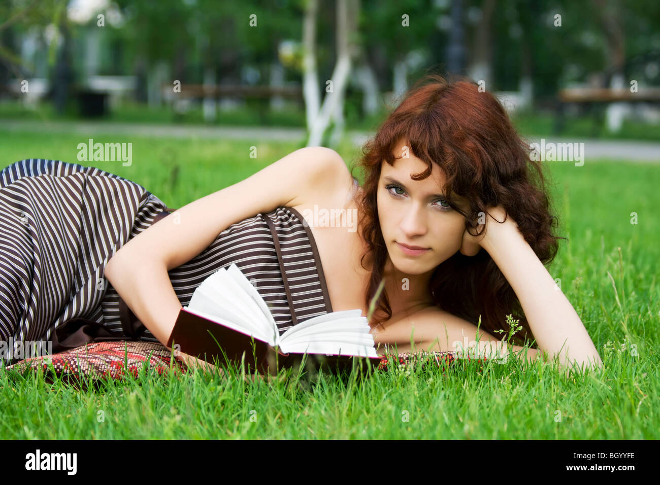 Young woman reading a book on nature Stock Photo - Alamy