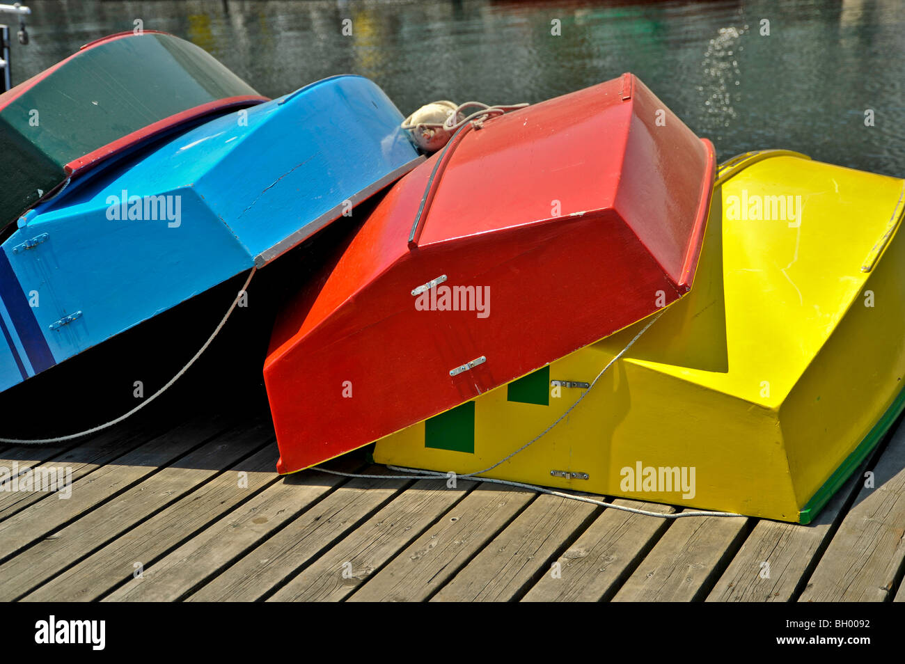 Four colorful wooden boats stack on a dock Stock Photo - Alamy