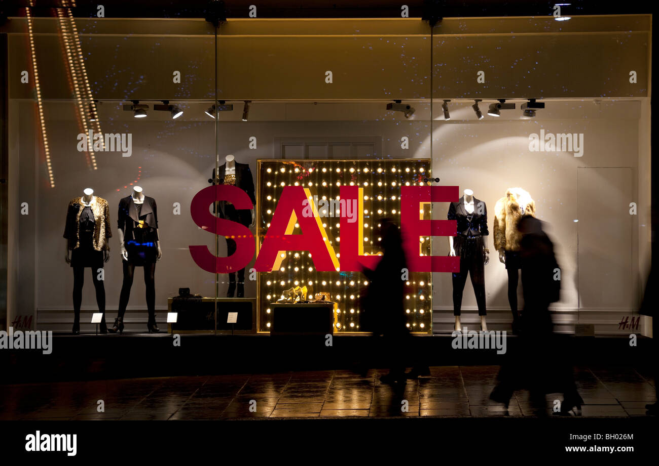 Sale sign in illuminated shop window at night Stock Photo - Alamy