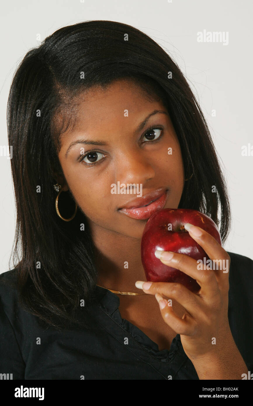 African American Woman in early 20's eating apple Stock Photo - Alamy
