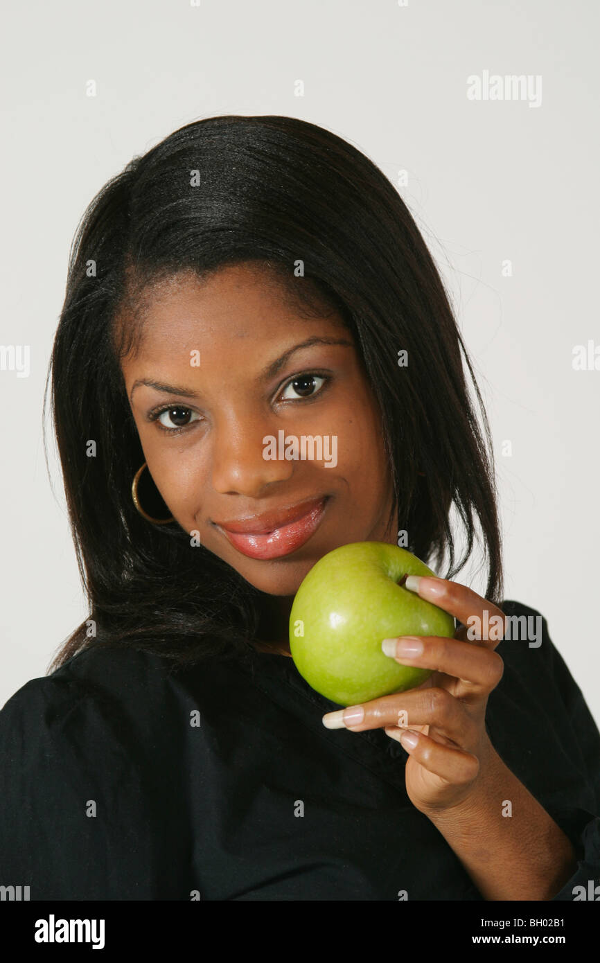 African American Woman in early 20's eating apple Stock Photo - Alamy