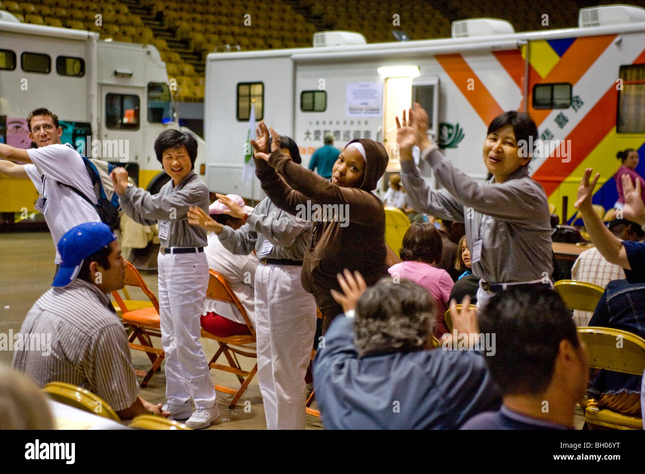 Volunteers stage an impromptu dance to entertain people who waited in ...