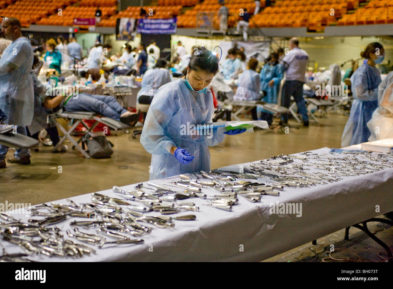 Sterilized dental instruments are laid out on a long table while ...