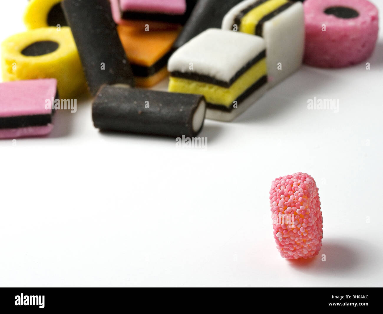 A selection of sweets slightly out of focus, with one separated and in ...