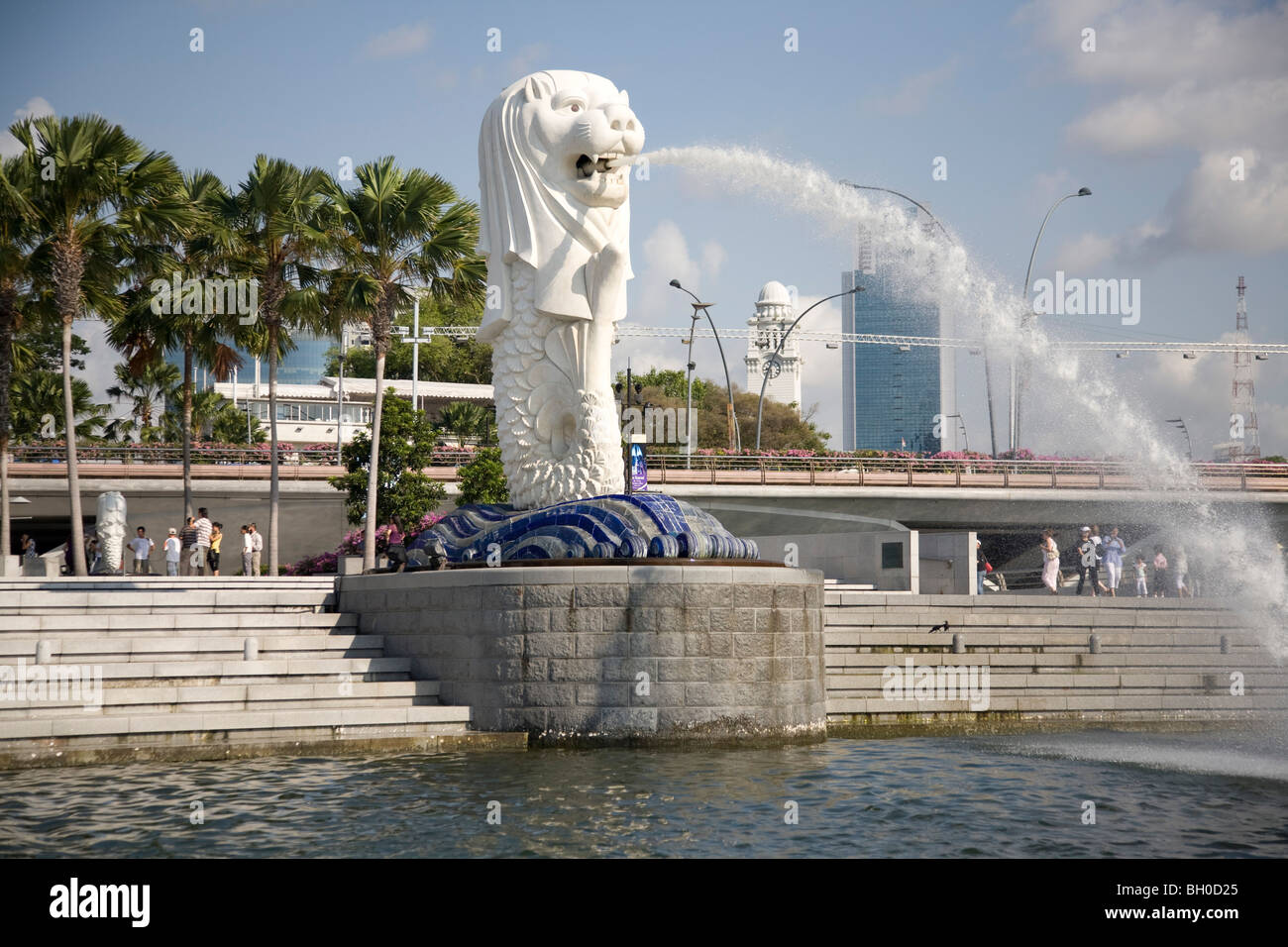 Singapore. Merlion fountain on waterfront with city buildings in ...