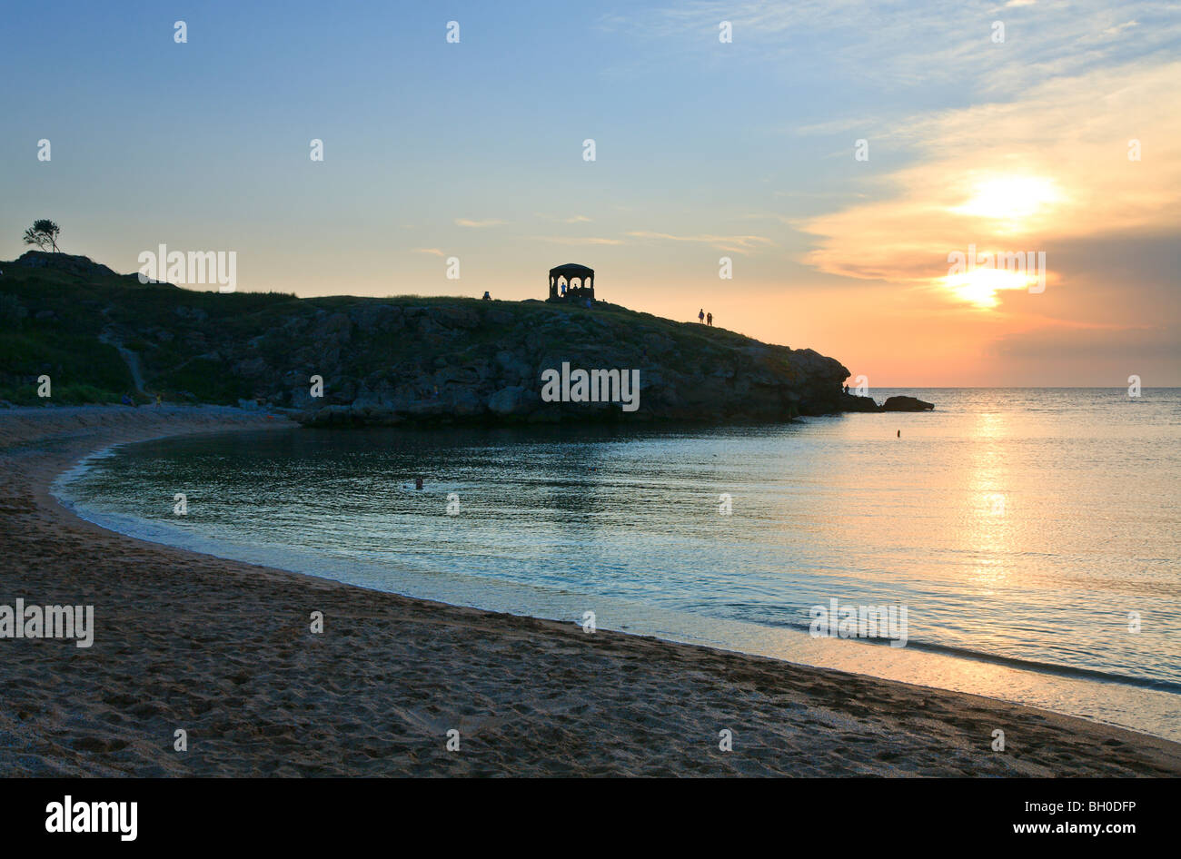 Sunset coastline and cape with pavilion at distance Stock Photo - Alamy